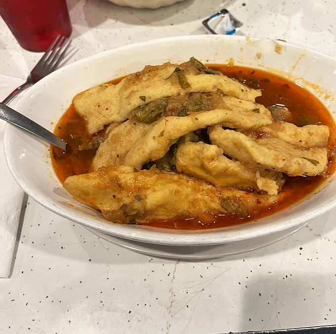 Chicken paprikash swimming in vibrant sauce &ndash; proof that sometimes the best things come in unassuming bowls.