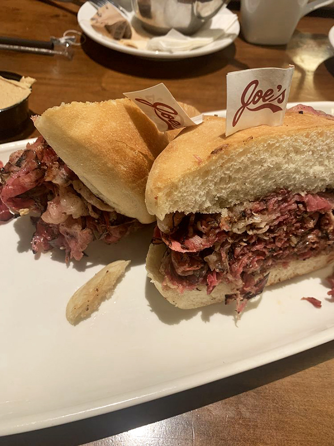 The pastrami sandwich arrives with its own flag, as if claiming territory in your heart. One bite and you'll surrender willingly.
