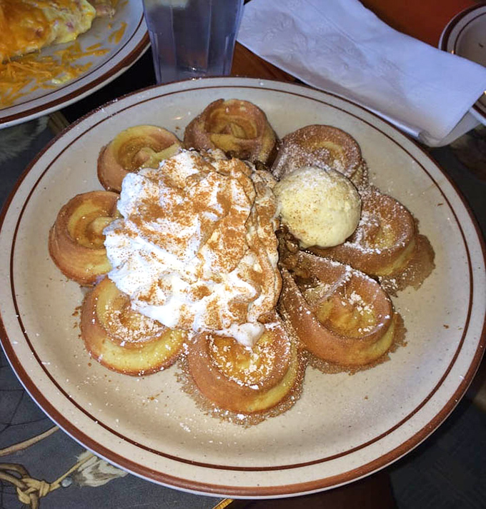 Belgian waffles arranged like flower petals, topped with whipped cream and waiting to transform your ordinary morning into something worth Instagramming.