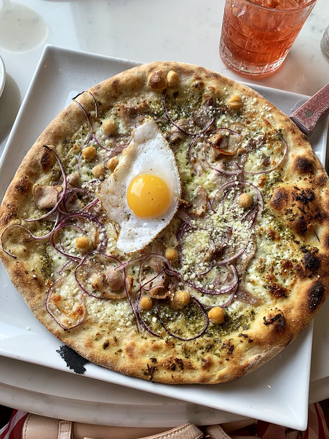 Breakfast pizza that answers the eternal question: "Why wait until dinner?" That sunny-side egg in the center is basically winking at you.