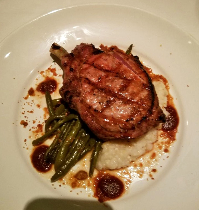 A pork chop so perfectly cooked it deserves its own Instagram account, nestled on creamy mashed potatoes with green beans for color (and conscience).