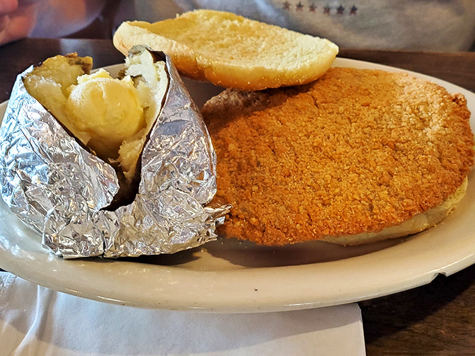Country-fried steak with a golden crust that audibly crackles with each bite, paired with a baked potato wrapped like a precious gift. Comfort food engineering at its finest.