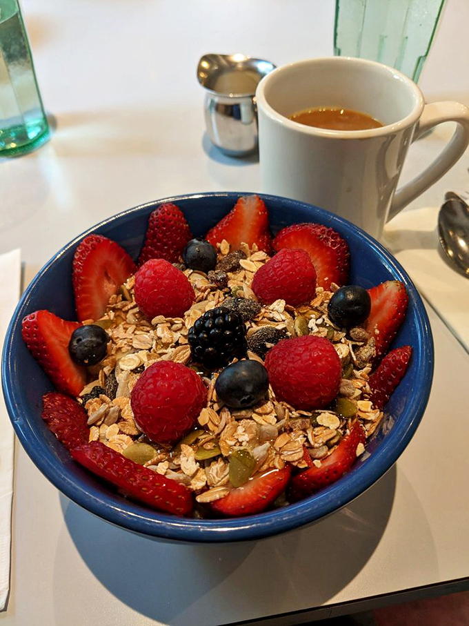 A blue bowl of oatmeal transformed into something magical with berries, nuts, and honey. Grandma would approve, but this isn't her recipe.