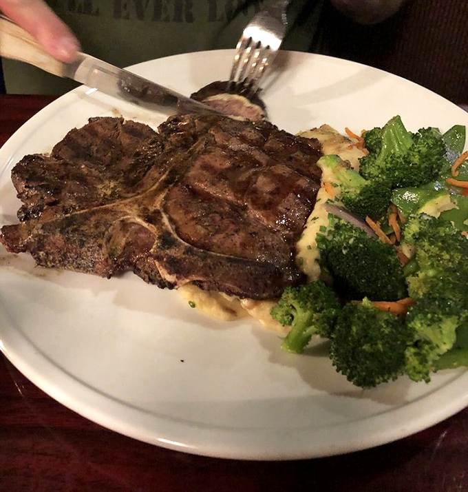 Behold the porterhouse in its natural habitat&mdash;perfectly seared, resting beside fresh broccoli and mashed potatoes. This isn't just dinner; it's a celebration on a plate.