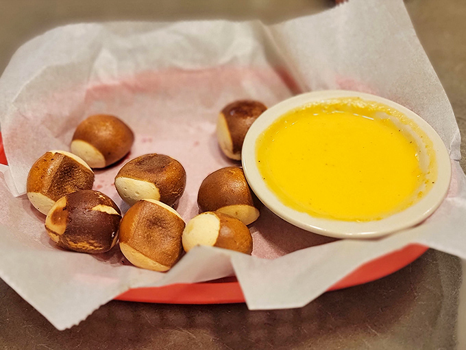 These pretzel bites arrive golden-brown and glistening, ready for their inevitable baptism in that pool of liquid gold cheese sauce.