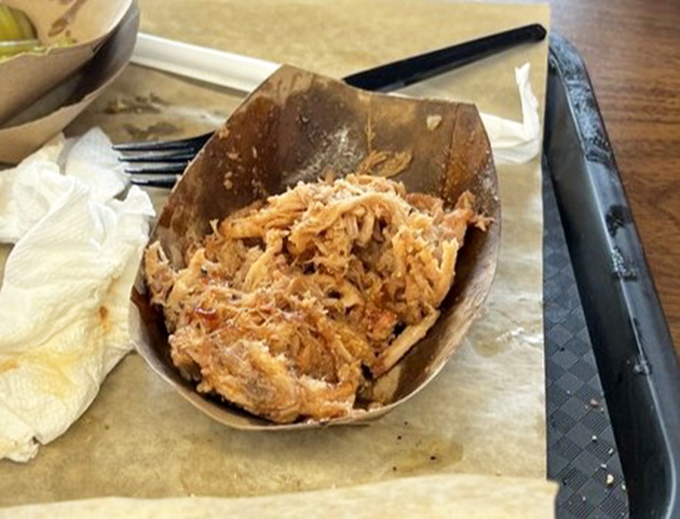 Pulled pork that's been coaxed into submission, each strand maintaining its dignity while joining the collective smoky celebration in your mouth.