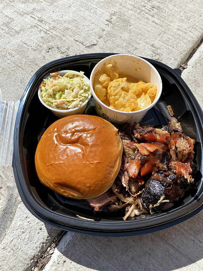 The barbecue trifecta: tender pulled meat, creamy mac and cheese, and fresh slaw &ndash; a to-go container that's practically begging to be photographed before devouring.