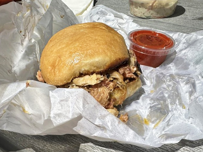 The pulled pork sandwich that launched a thousand road trips. That golden bun barely contains the smoky, tender meat that's about to change your lunch standards forever.