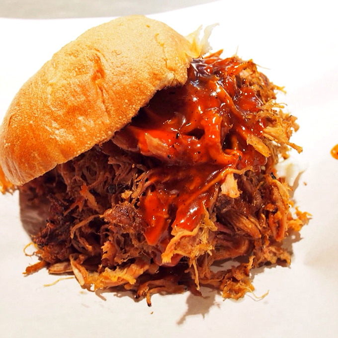 The pulled pork sandwich doesn't just satisfy hunger &ndash; it resolves existential crises with each tender, sauce-soaked bite.