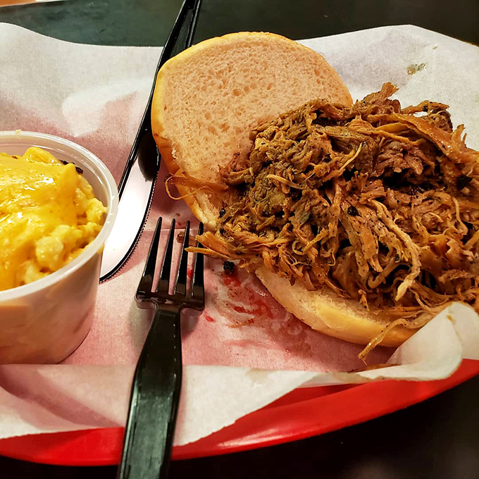 Pulled pork that actually requires zero pulling—it surrenders willingly after its long smoke bath. The mac and cheese isn't a side; it's an essential companion.