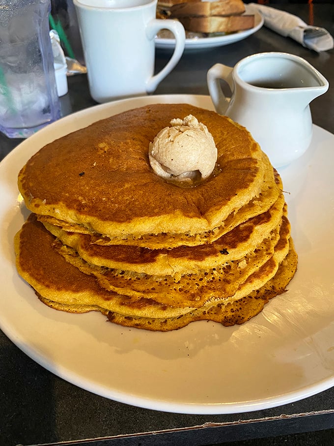 Pancakes stacked higher than your weekend ambitions, crowned with a melting pat of butter that's basically saying "Good morning, gorgeous."