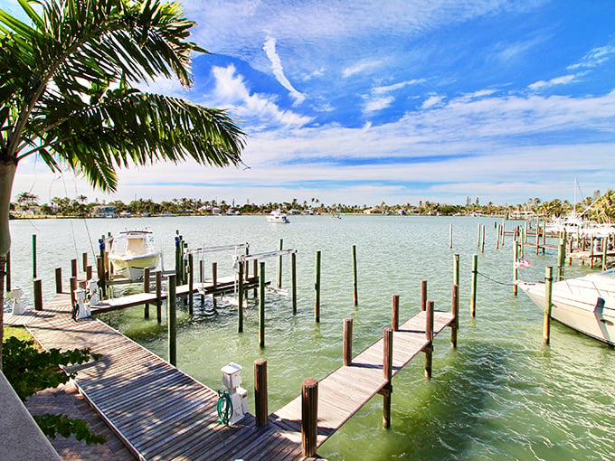 The marina's wooden docks create a geometric ballet of lines and reflections &ndash; each slip a parking space for someone's floating piece of freedom.
