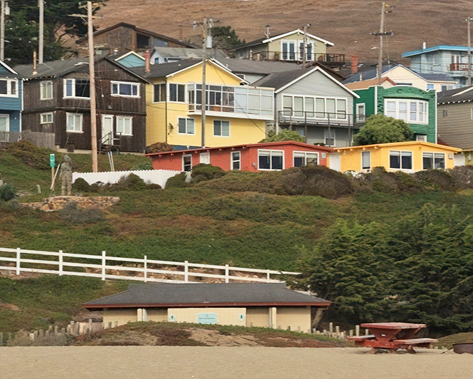 A hillside rainbow of coastal cottages, each one perfectly positioned to catch tomorrow's sunrise and tonight's dreams.