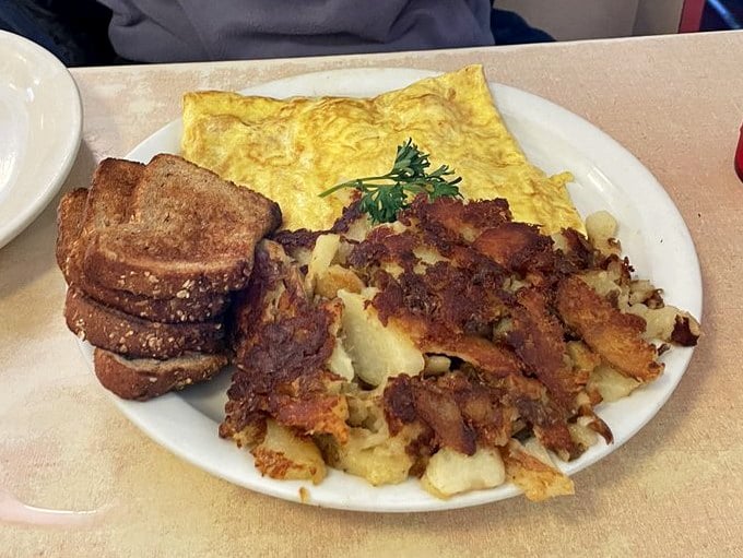 A perfectly cooked omelet with toast and hash browns&mdash;the holy trinity of diner breakfast, executed with the precision of a culinary sonnet.