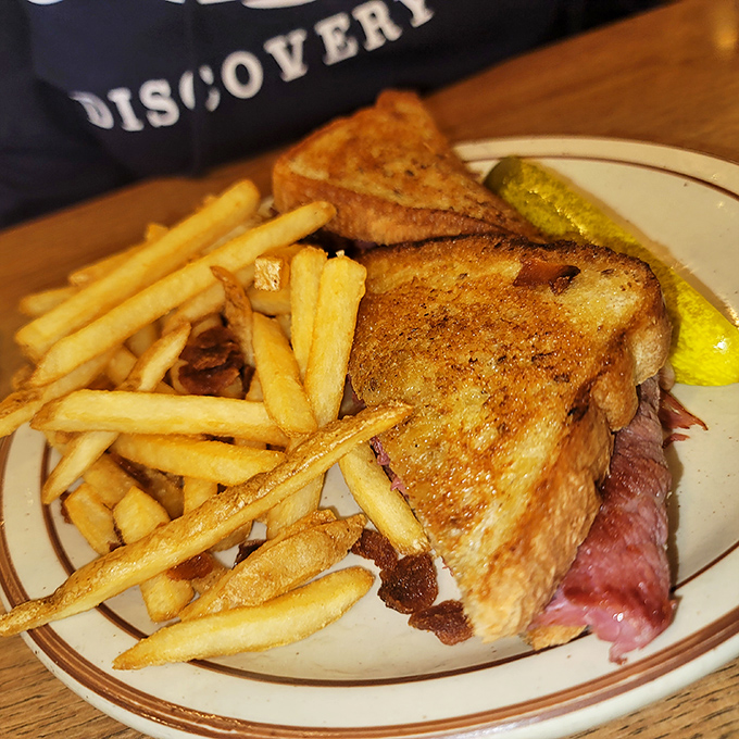 Golden-brown toast, crispy fries, and a sandwich that would make any New York deli nod in respect. The pickle stands guard.