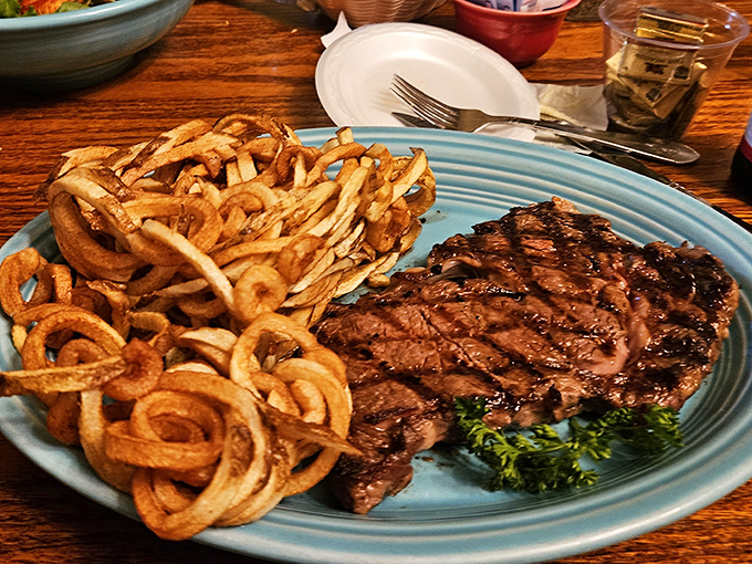 A ribeye that's seen just the right amount of flame, paired with curly fries that spiral into crispy perfection. Carnivore poetry on a plate.