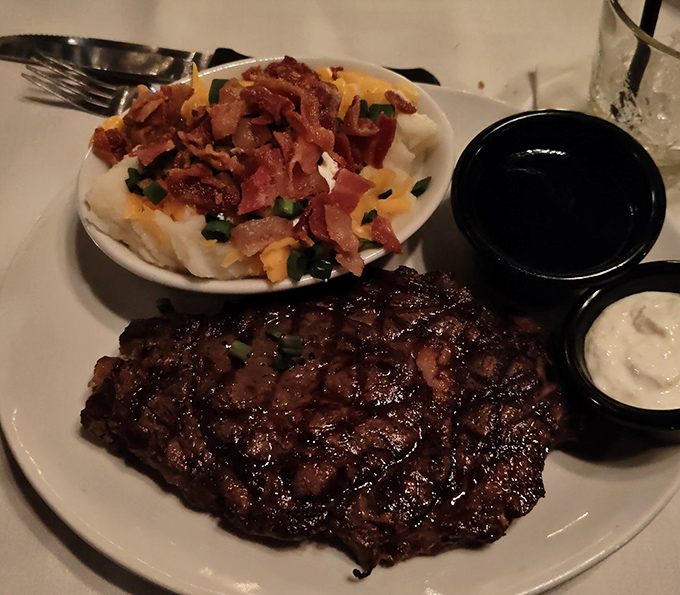 A ribeye with perfect grill marks alongside a loaded baked potato. Some relationships were just meant to be&mdash;like beef and fire.