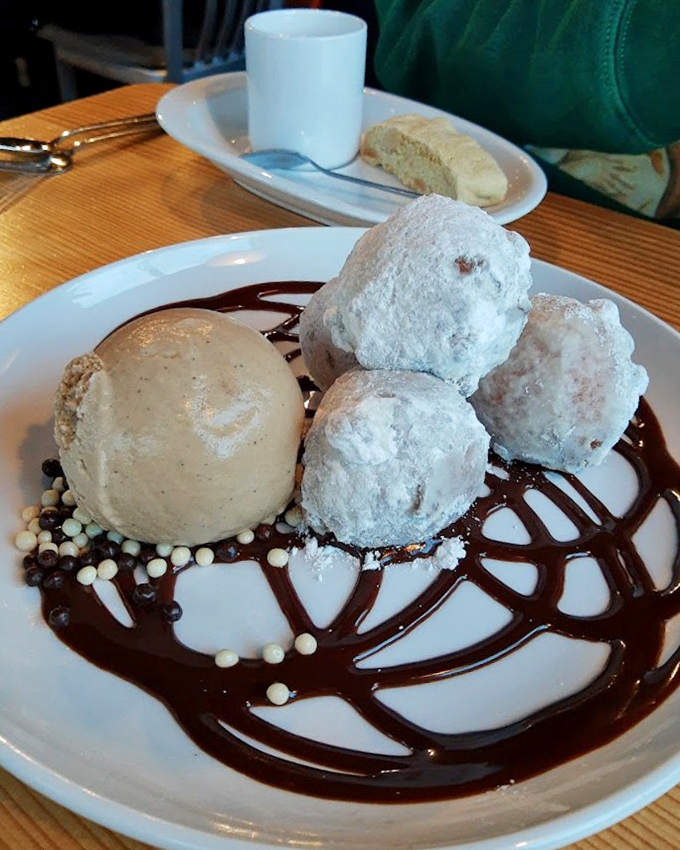 These aren't your carnival donuts &ndash; they're cloud-like pillows of sweetness dancing on a chocolate canvas. Dessert nirvana has been achieved.