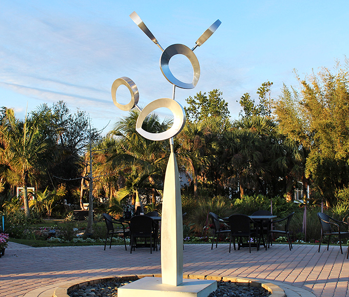 This sleek metal sculpture catches sunlight like a cosmic dancer, turning physics into poetry against the Florida sky.