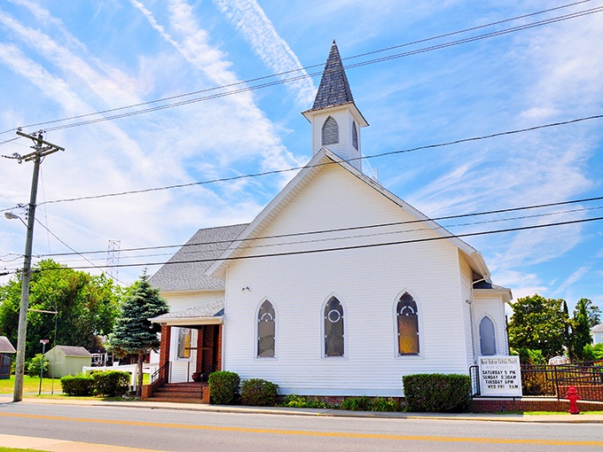 This pristine white church stands as a serene landmark against Chincoteague's blue skies, offering spiritual refuge amid vacation adventures.