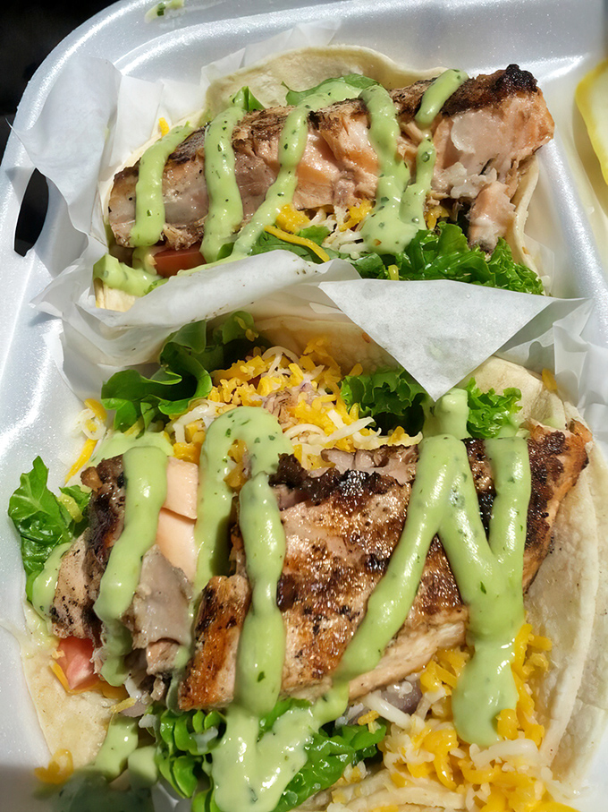 These fish tacos aren't just lunch; they're edible postcards from the Pacific – grilled salmon, fresh greens, and that signature green sauce that haunts your dreams.