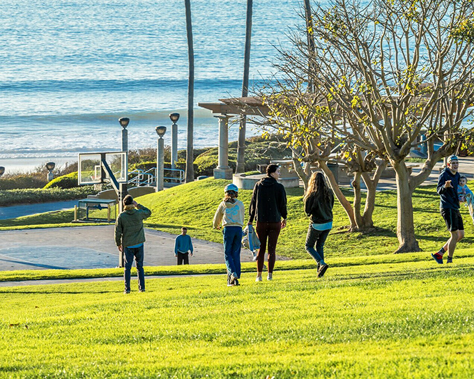 Families stroll through Salt Creek Beach Park, where the grass is always greener when it comes with panoramic ocean views and sea-salt-kissed breezes.