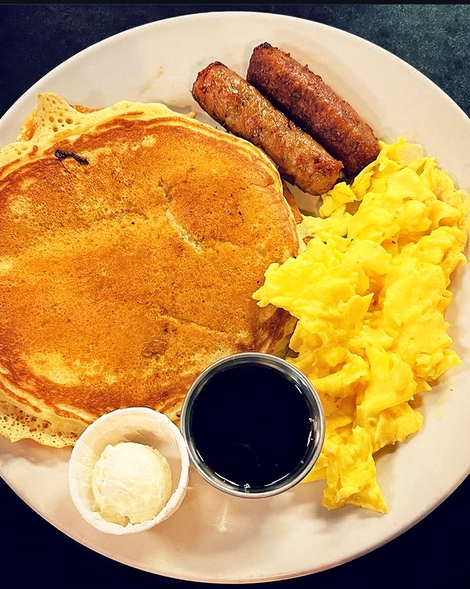 The breakfast trinity: golden pancake, scrambled eggs, and sausage links. Simple pleasures that remind us why morning meals matter.