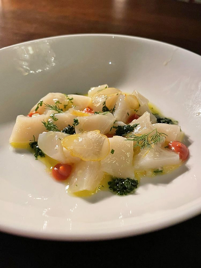 Ocean treasures transformed into edible art. These delicate scallops swimming in citrus oil make you wonder why anyone bothers cooking seafood at all.