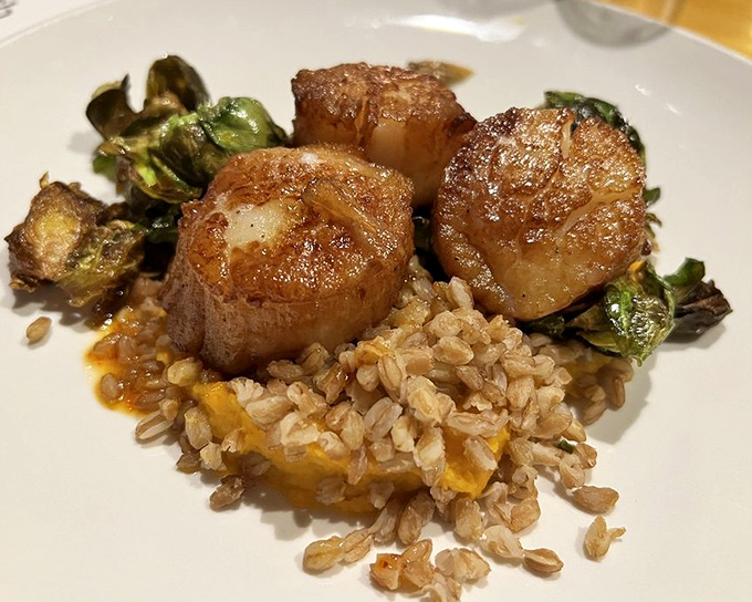 Scallops that could make a mermaid jealous, perched atop a bed of farro like culinary royalty. The Brussels sprouts add earthy punctuation to this seafood sonnet.