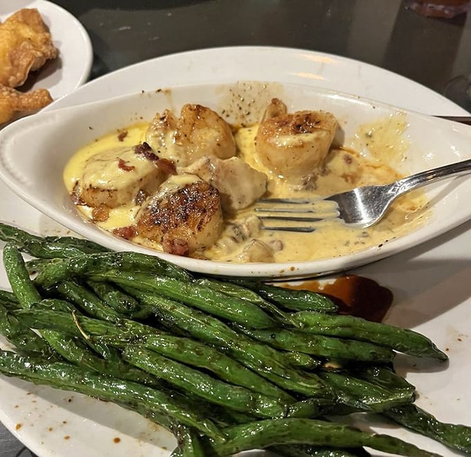 Scallops seared to caramelized perfection swim in a creamy sauce alongside vibrant green beans&mdash;proof that small-town Ohio knows seafood.