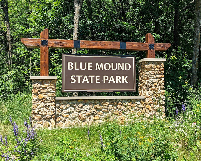 The entrance sign, surrounded by wildflowers, stands like nature's welcome mat. First impressions matter, even in the wilderness.