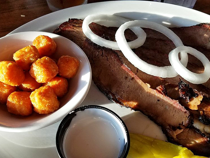 Brisket with that textbook smoke ring and perfect bark. Those onion rings aren't just garnish &ndash; they're silent supporting actors.