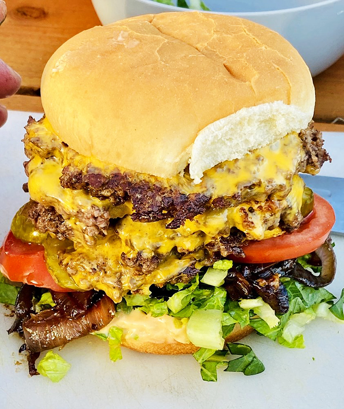 Behold the skyscraper of sandwiches! This towering burger defies both gravity and the capacity of the human jaw.