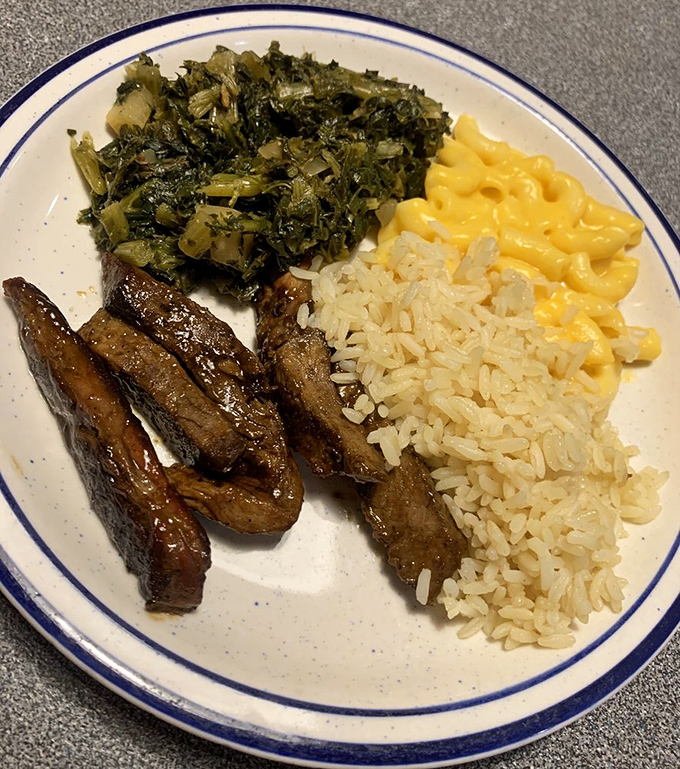 Southern comfort on a plate: collard greens, mac and cheese, and steak tips that didn't get the memo about being fancy.