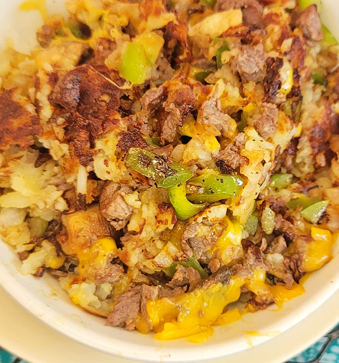 A beautiful chaos of steak, potatoes, peppers and cheese &ndash; the kind of skillet that makes you want to cancel your plans for the day.