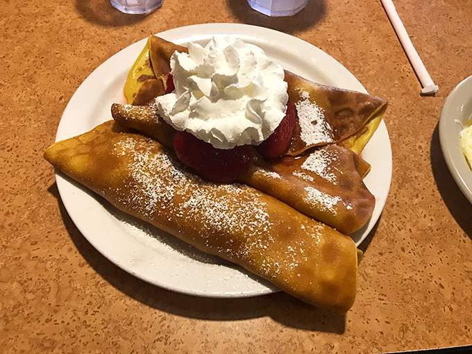 These crepes aren't just filled with strawberries; they're wrapped around joy and dusted with memories of simpler times.