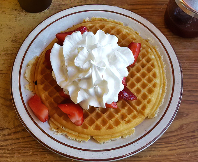 Strawberry waffles topped with a cloud of whipped cream &ndash; proof that sometimes the simplest combinations are the most irresistible.