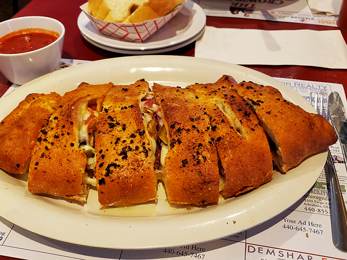 The stromboli arrives pre-sliced, as if to say, "We know you're impatient to get to the good stuff." That golden crust is practically winking at you.