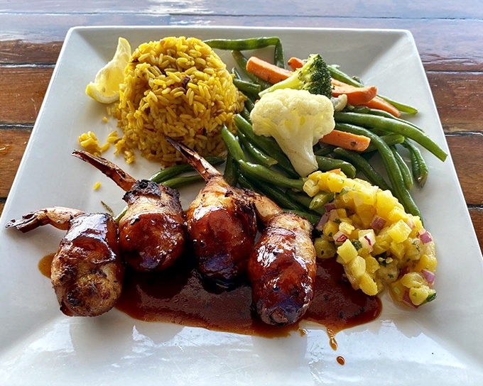 Bacon-wrapped shrimp nestled among colorful vegetables and saffron rice&mdash;proof that sometimes the best things in life come in small, delicious packages.