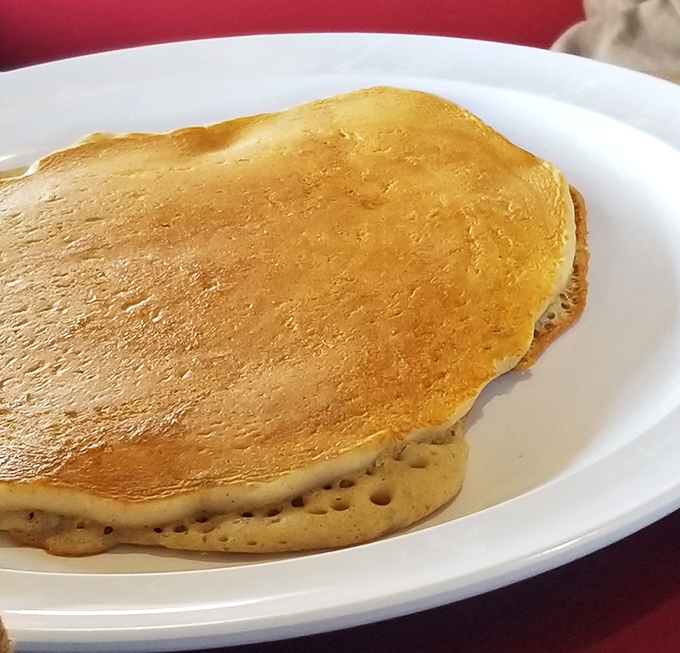 This pancake isn't just large, it's contemplating taking over neighboring counties. Golden, fluffy, and unapologetically enormous.