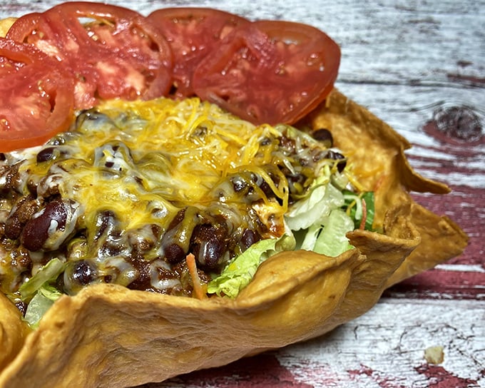 A taco salad that breaks all the rules – crispy shell, melted cheese, and seasoned beef creating the kind of mess worth making in public.