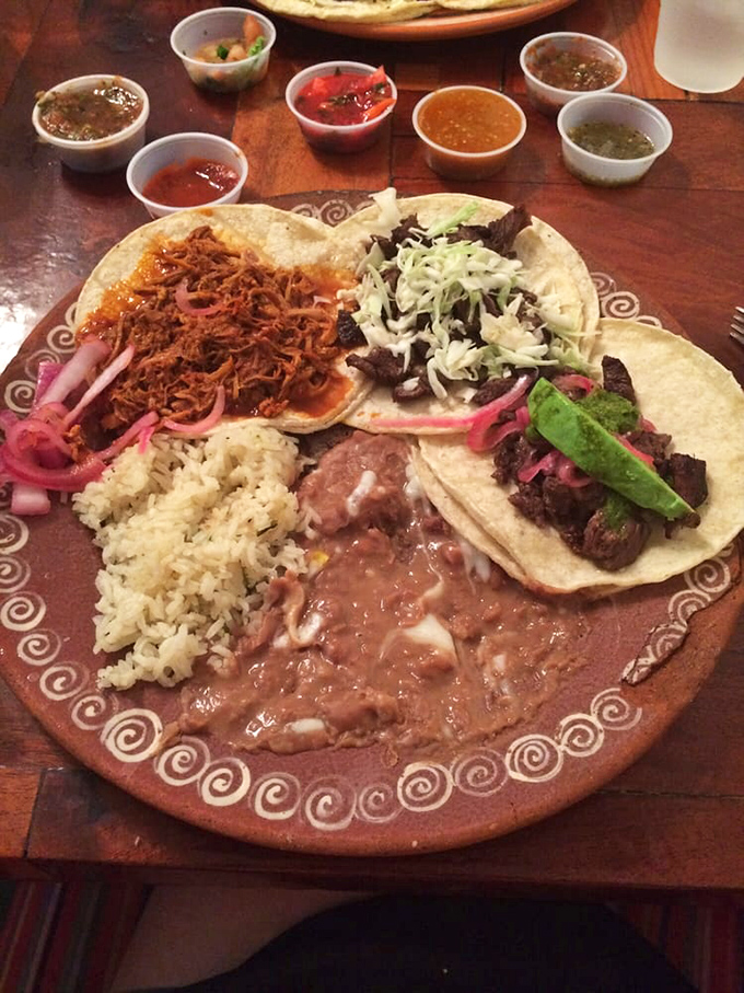 A fiesta on a plate! Multiple taco varieties surrounded by rice, beans, and a rainbow of salsas&mdash;proof that variety truly is the spice of life.