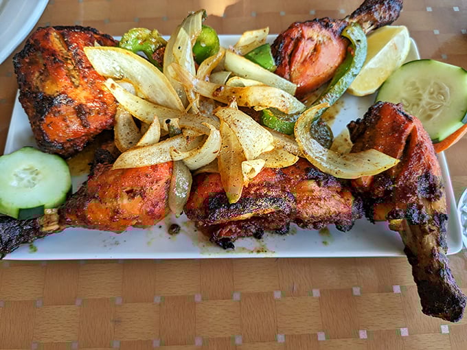 Tandoori chicken with its signature crimson hue and charred edges arrives with grilled vegetables and cucumber &ndash; proof that simplicity, when done right, is magnificent.