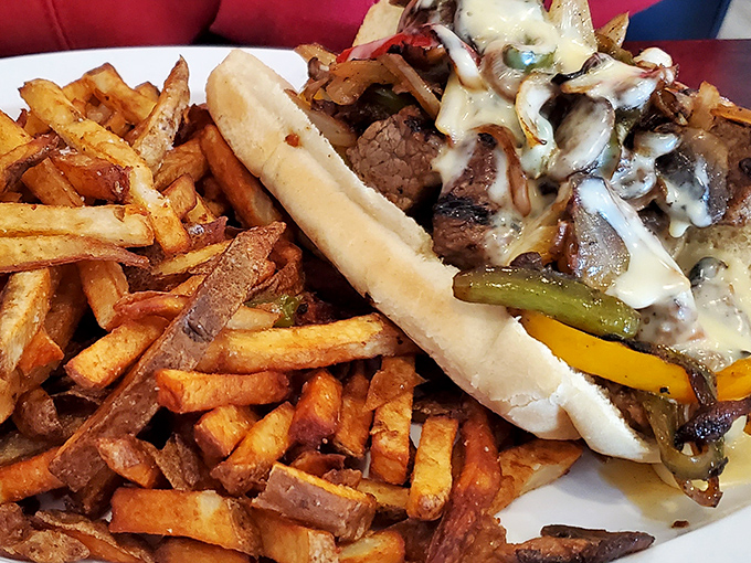 The Philly cheesesteak arrives like a savory work of art&mdash;hand-cut fries standing at attention beside a sandwich that demands to be photographed first.