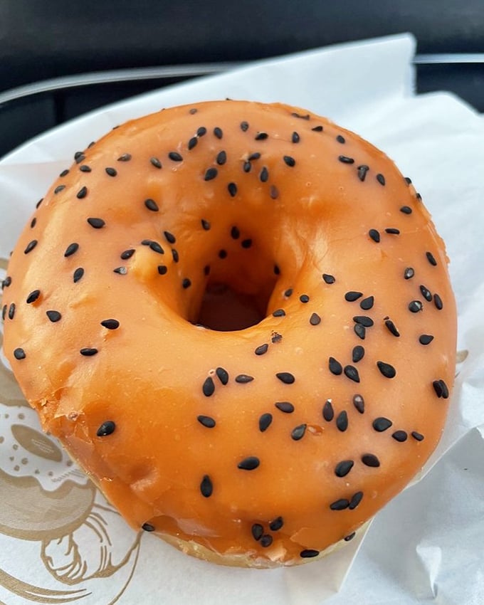 The Thai Tea donut with its vibrant orange glaze and black sesame seeds is like a passport stamp for your taste buds. No airline ticket required.