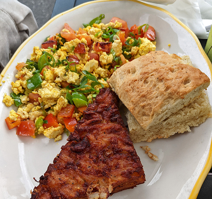 The holy trinity of breakfast: perfectly scrambled eggs, crispy bacon, and a biscuit that could make a Southerner weep with joy.