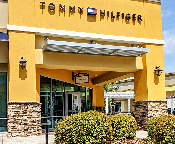 Tommy Hilfiger's sunny yellow storefront beckons like a retail lighthouse, guiding fashion-seekers safely to harbor—and away from full retail prices.