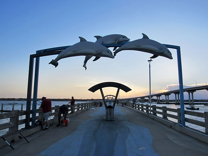 Vilano Beach's pier stretches into sunset like nature's red carpet, complete with dolphin sculptures as paparazzi.