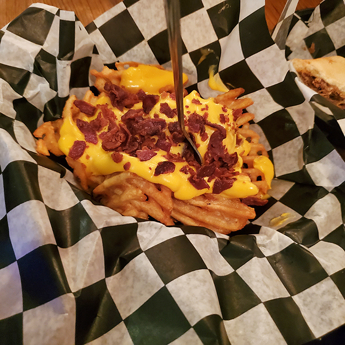 Cheese fries with bacon bits that make you question why you ever bothered with plain fries. Diet culture's kryptonite in a checkered basket.