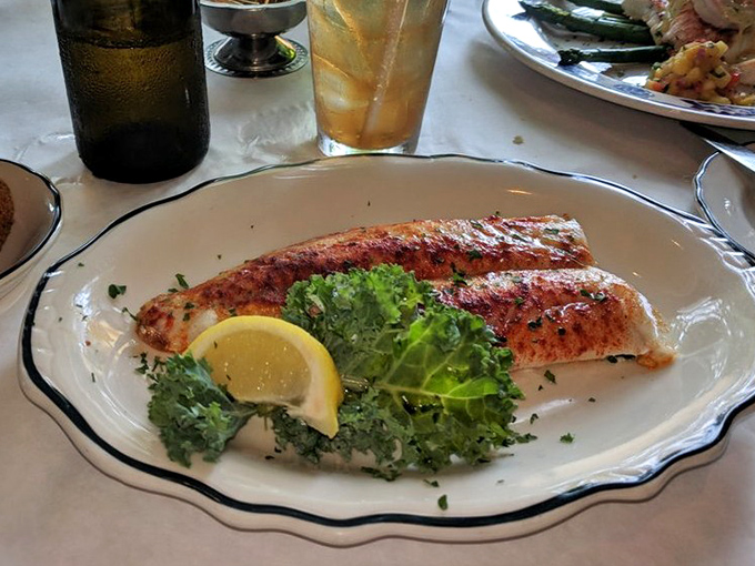 Perfectly grilled walleye resting on its bed of greens like Wisconsin royalty, with that lemon wedge standing by for a spritz of sunshine.